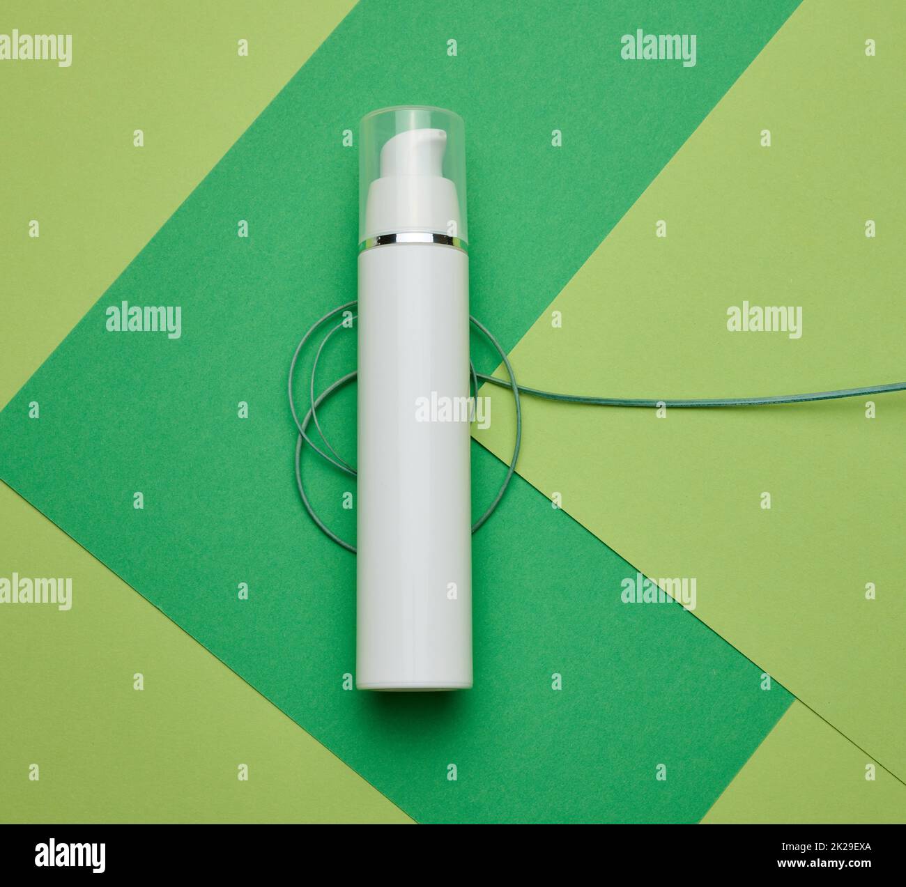 empty white plastic bottle on a green background. Cosmetic products for ...