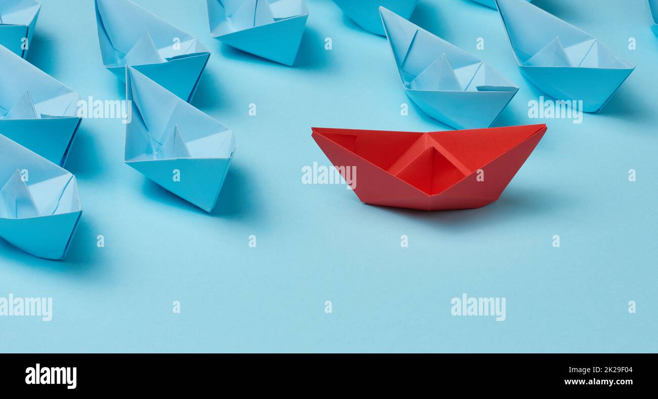 group of paper boats on a white background. concept of a strong leader ...