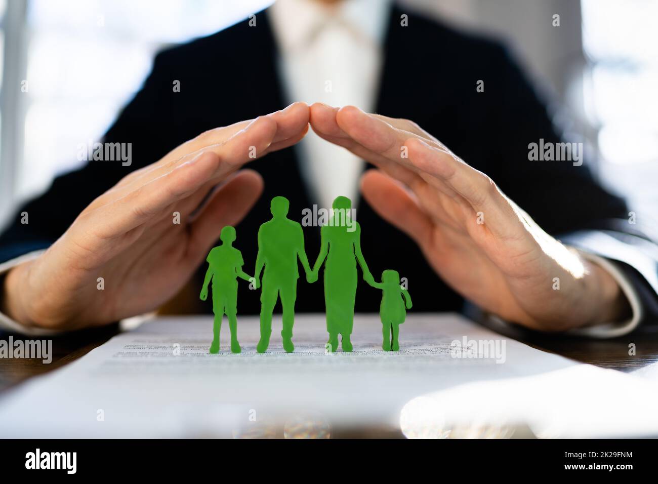 Cropped Image Of Businessman Covering Paper Family Stock Photo - Alamy