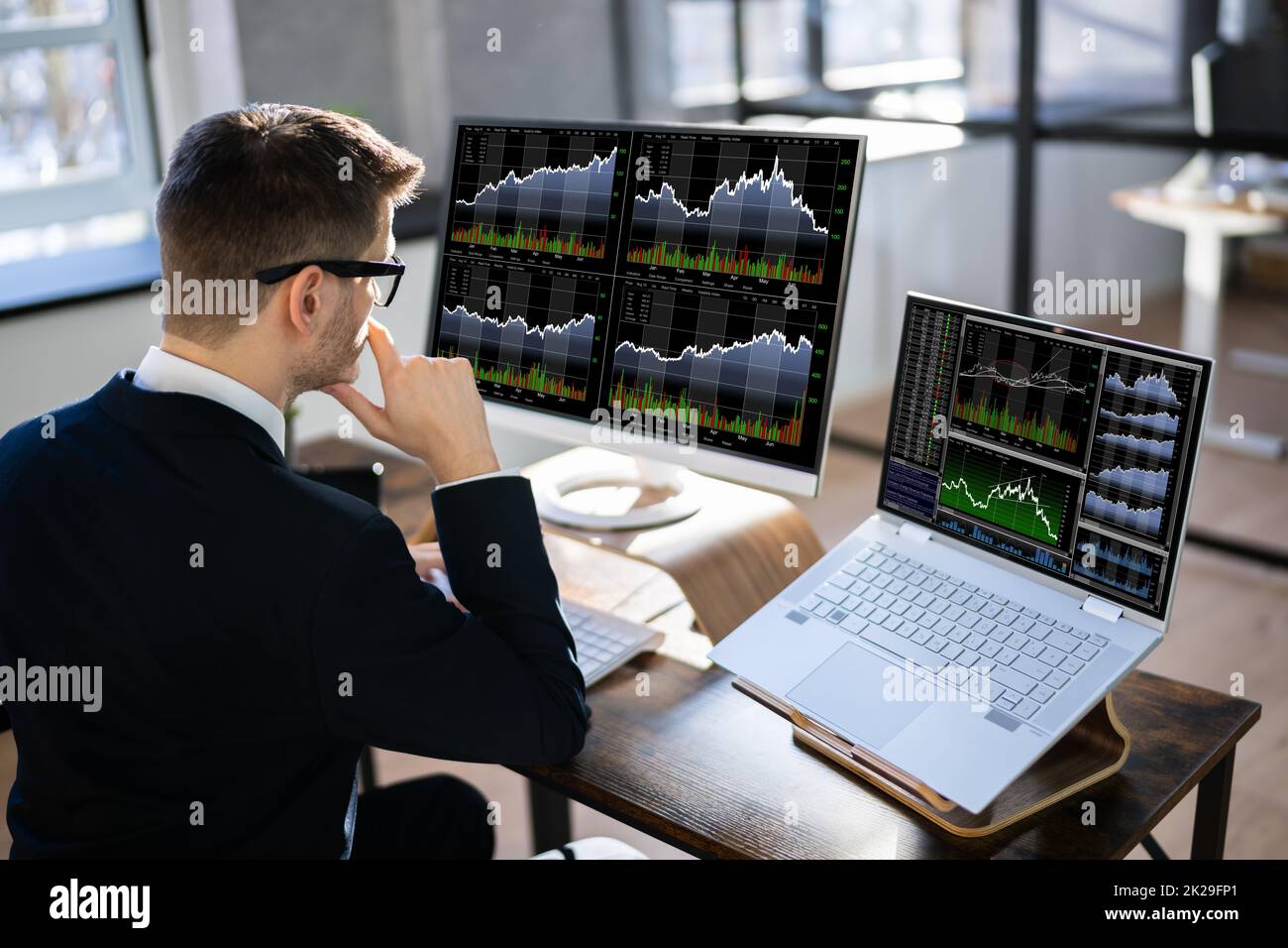Young Male Stock Market Broker Looking At Graph On Computer Stock Photo ...