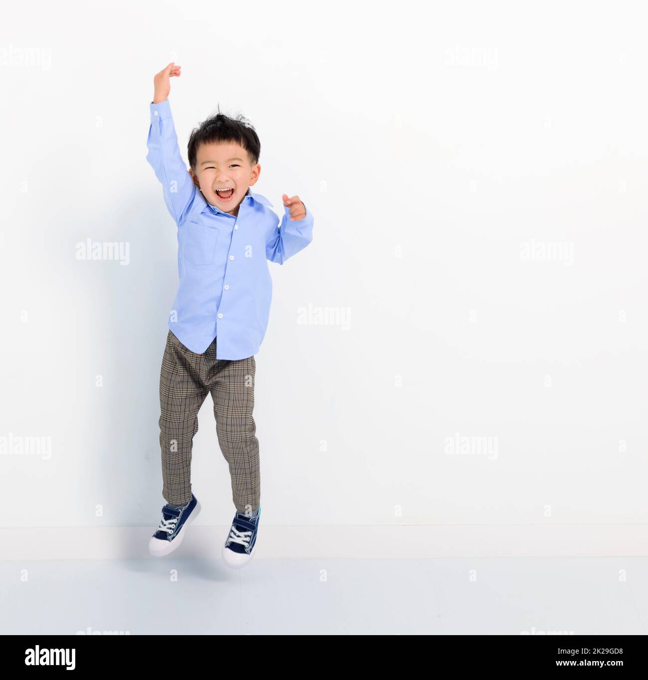 Happy little boy jumping on white background Stock Photo - Alamy