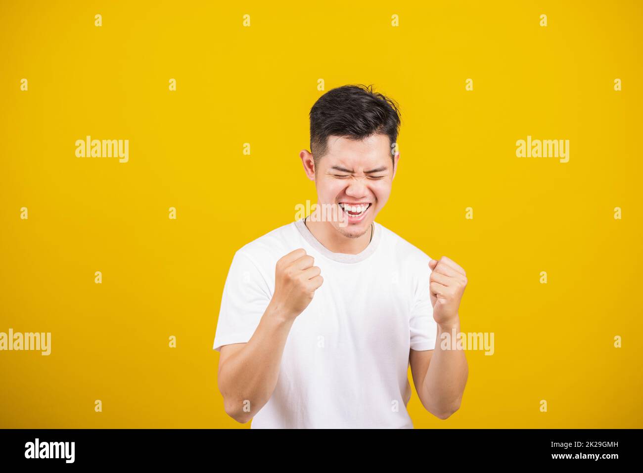 young man smile positive shaking hands enthusiastic shouting yes for ...