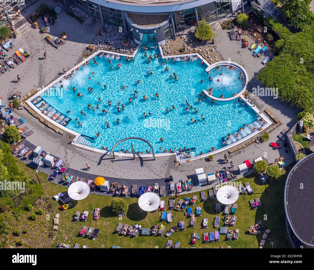 Adventure pool with bathers and sunbathing lawn hi-res stock ...