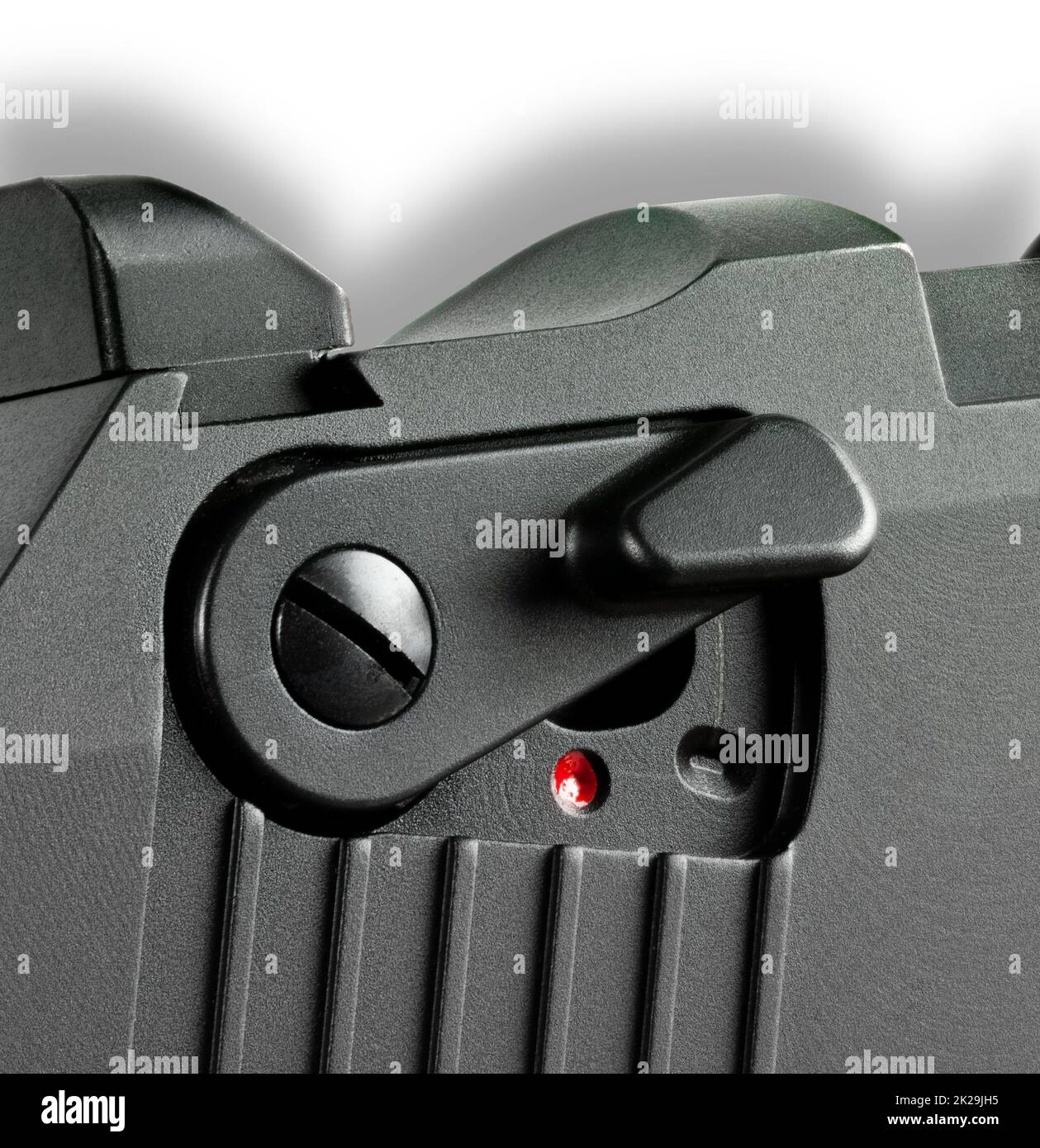 Gun safety moved to the firing position on white with shadow behind ...