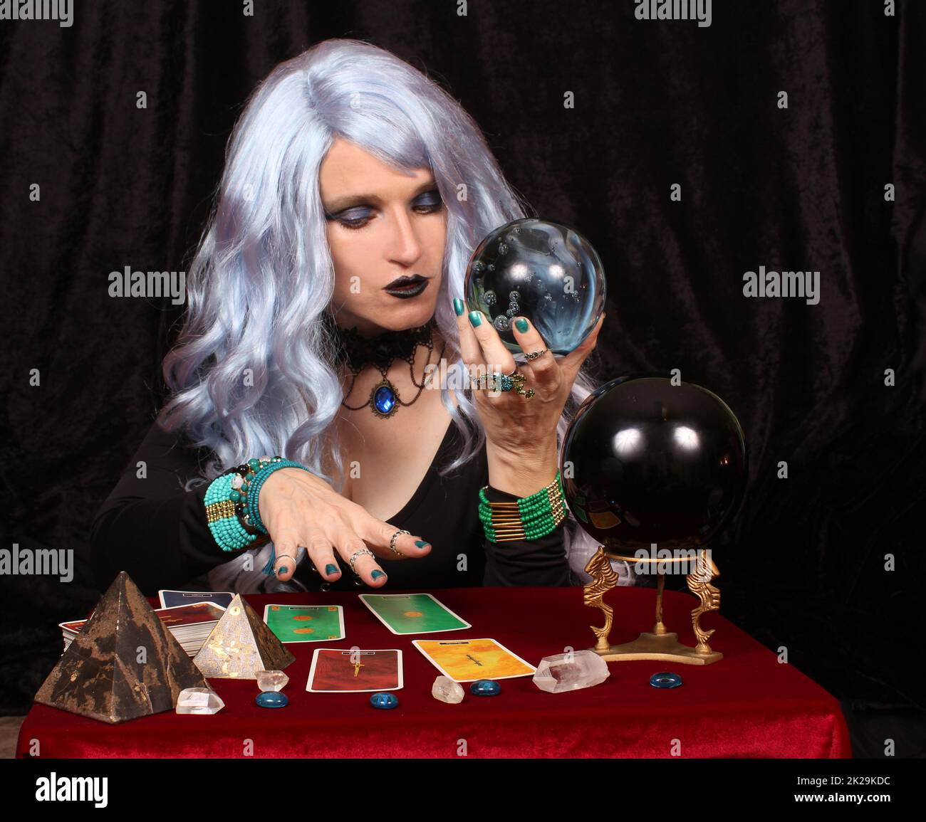 Psychic with blue hair, crystal ball and tarot cards Stock Photo - Alamy