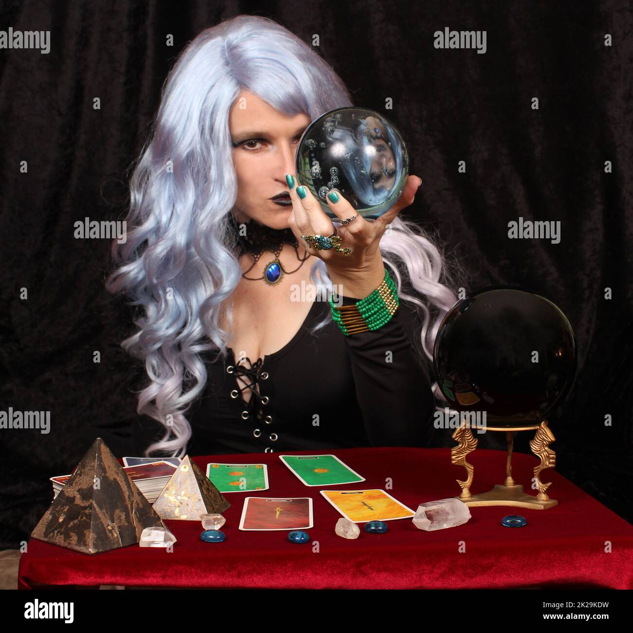 Psychic with blue hair, crystal ball and tarot cards Stock Photo - Alamy
