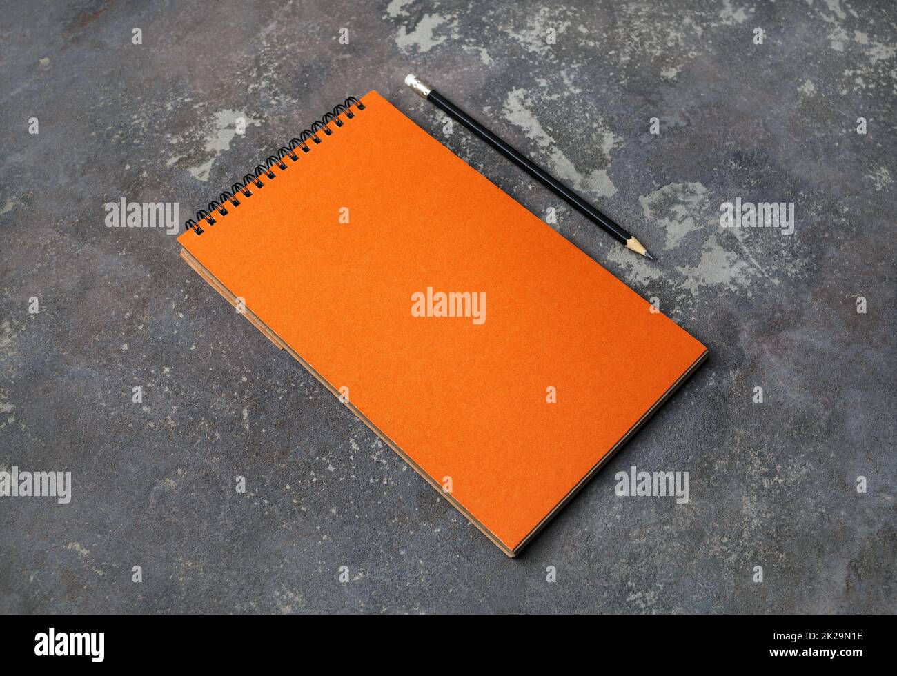 Orange notebook, pencil Stock Photo - Alamy