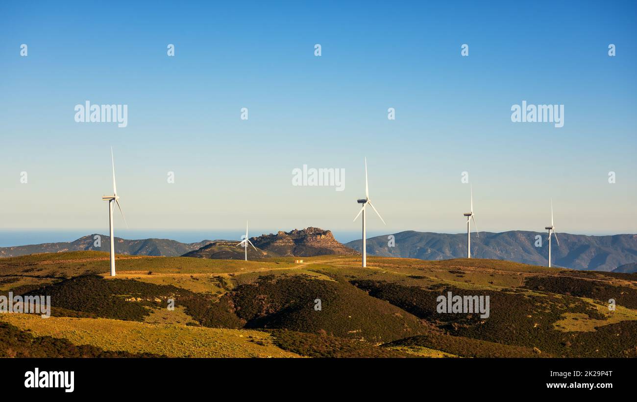 Turbines in a mountain wind farm at sunset. Ecological energy ...
