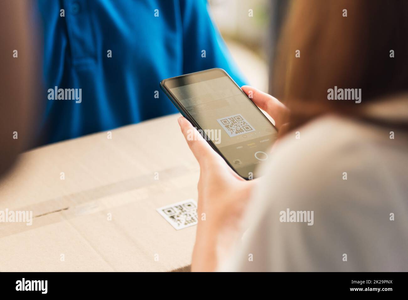 woman using mobile smartphone with QR code payment to receive parcel ...
