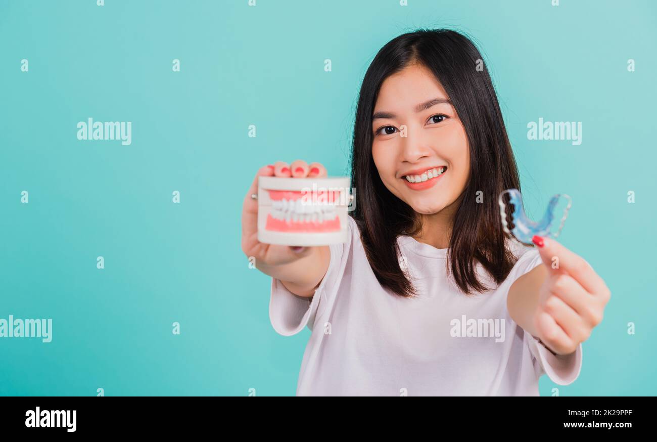 woman smiling holding silicone orthodontic retainers for teeth ...
