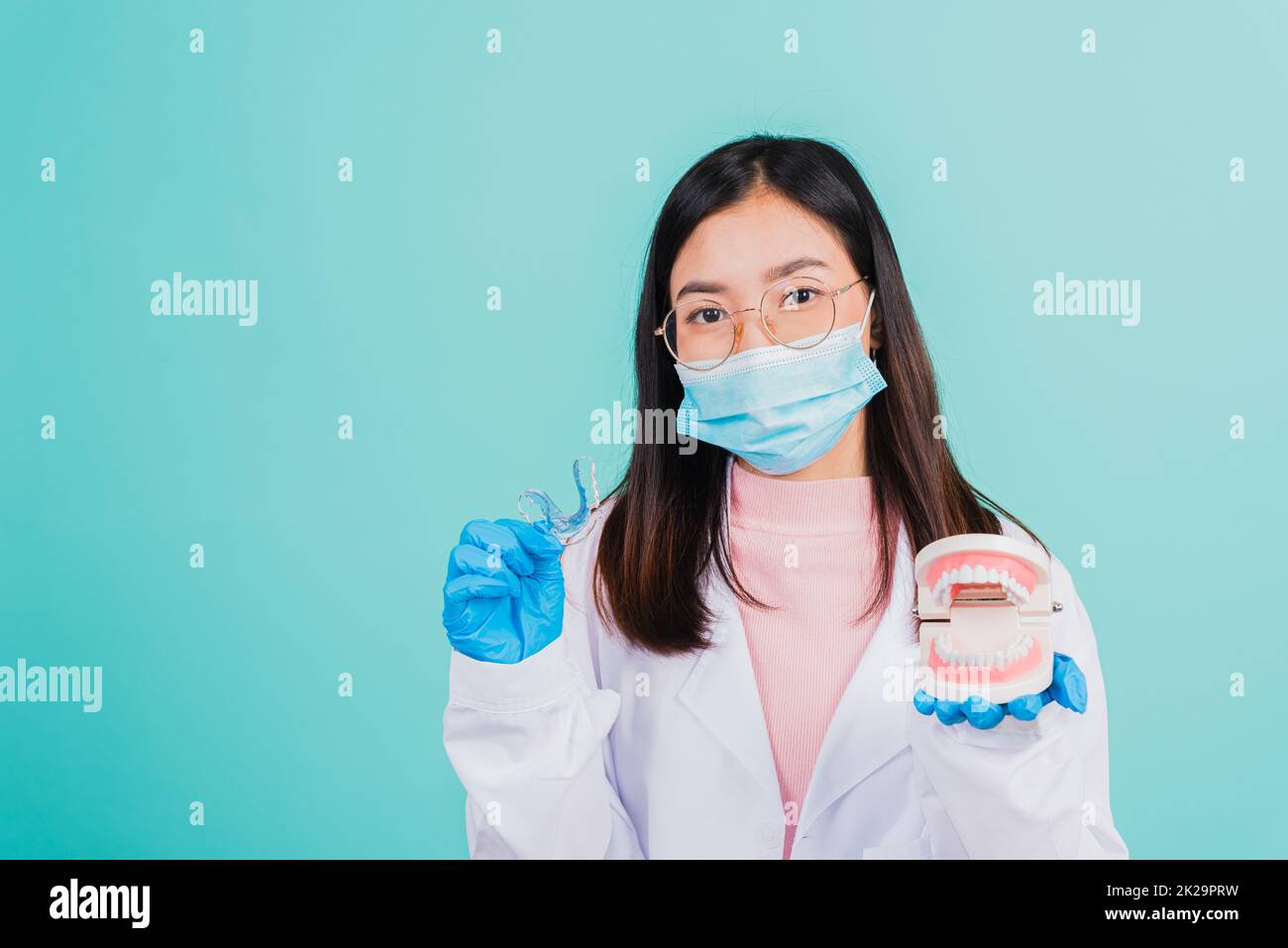 woman dentist holding silicone orthodontic retainers and model teeth ...