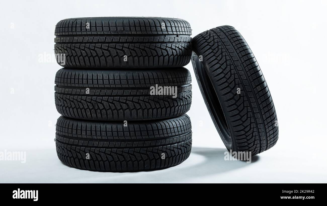 Stack of tires with one leaning wheel isolated on white background ...