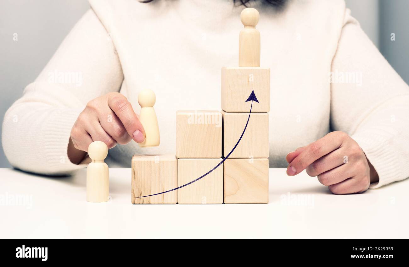 pyramids from wooden cubes and figurines of men on the table. The ...