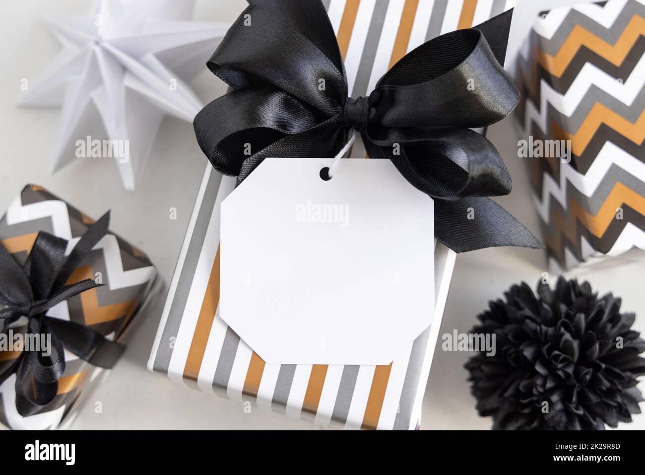 Wrapped present with blank gift tag and black bow close up, label ...