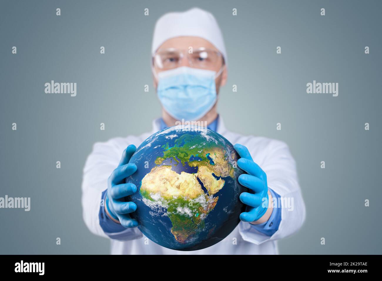 Doctor hold a earth globe in hands and a medical syringe with vaccine ...