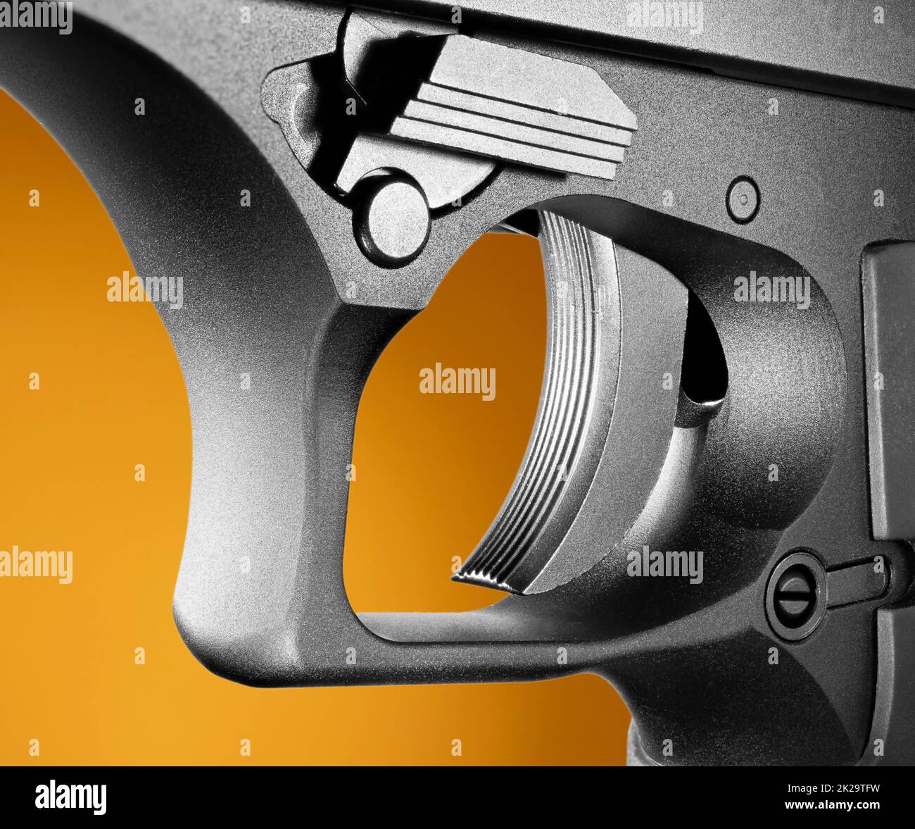 Closeup of a semi automatic pistol trigger with an orange and brown ...