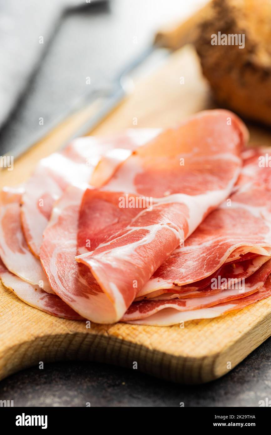 Italian dried ham. Coppa Stagionata on cutting board Stock Photo - Alamy