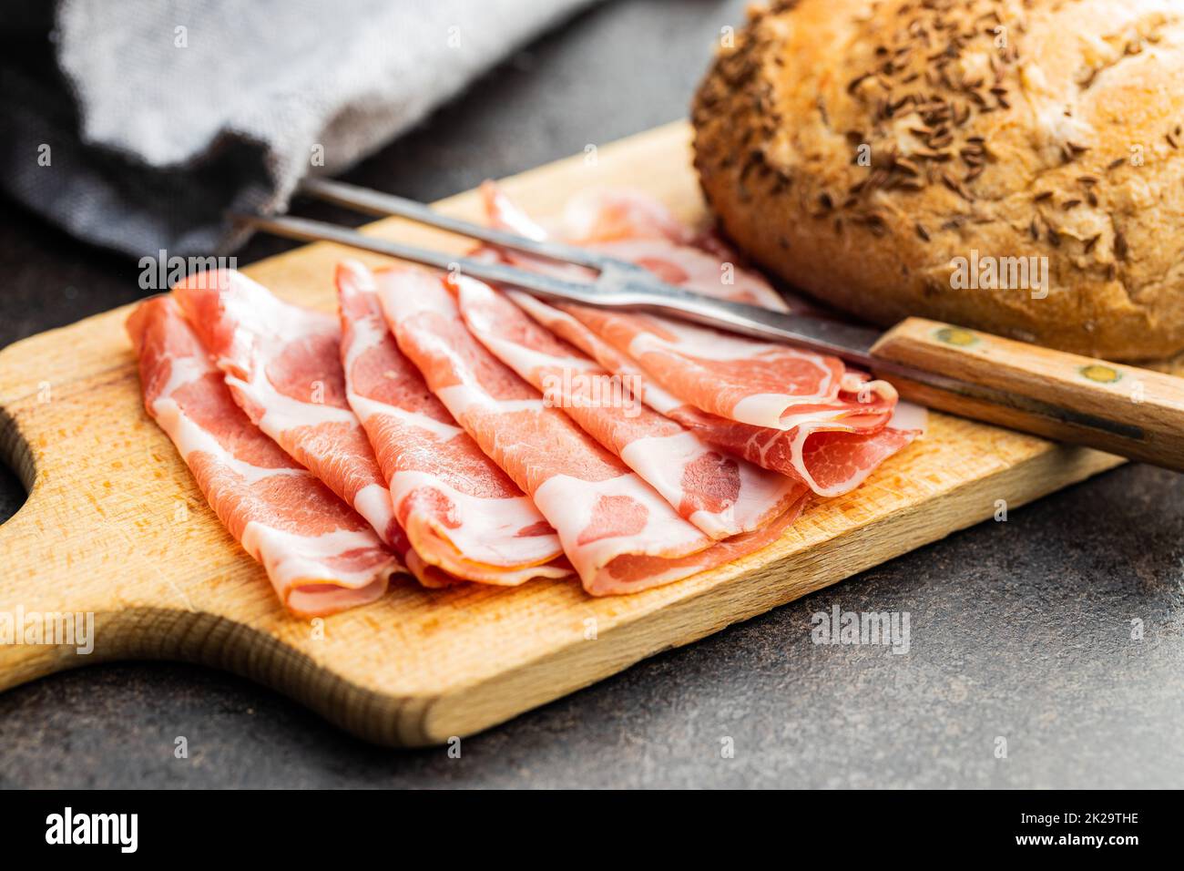 Italian dried ham. Coppa Stagionata on cutting board Stock Photo - Alamy