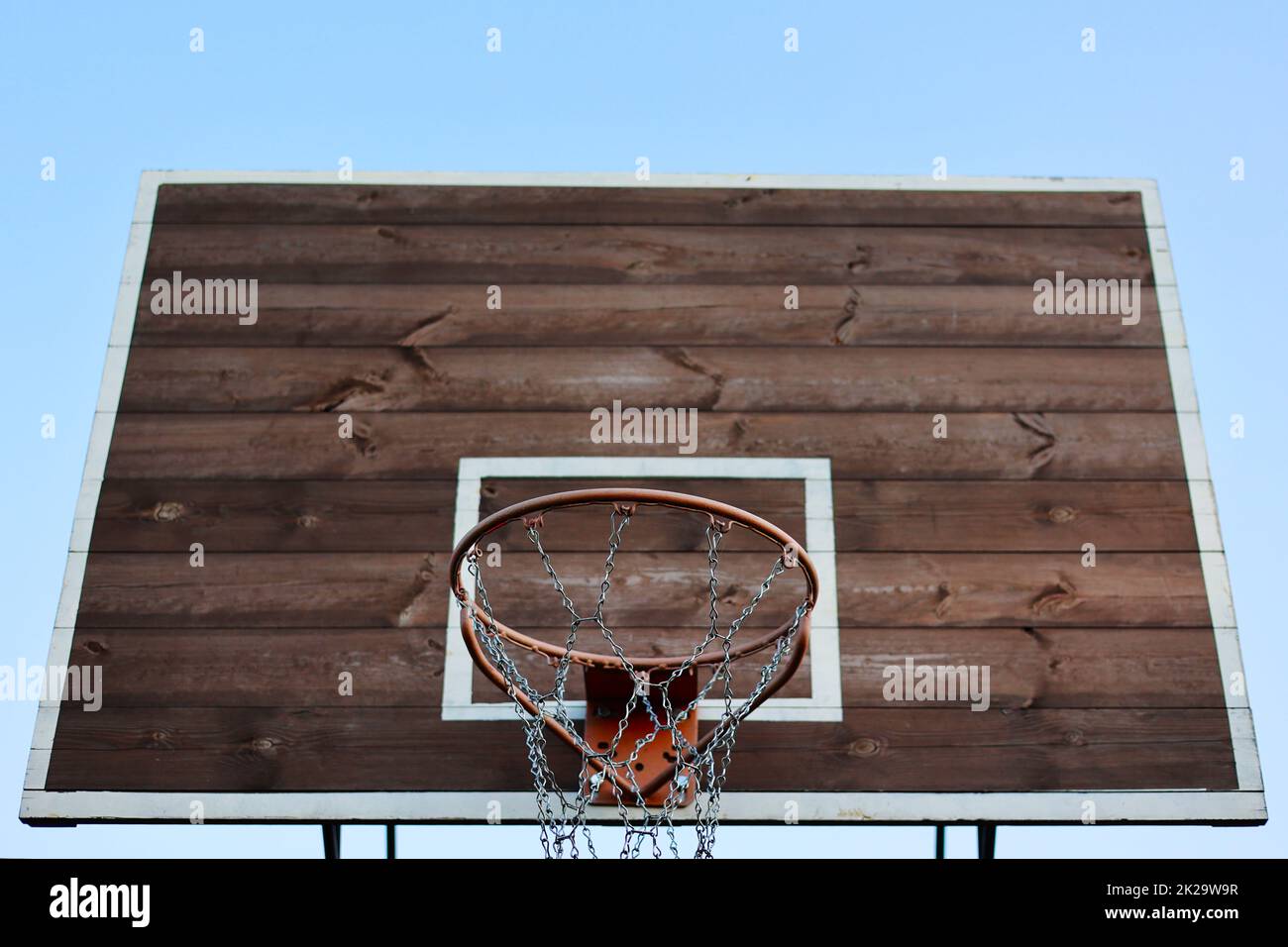 basketball hoop, metal net and wooden backboard for game on blue sky ...