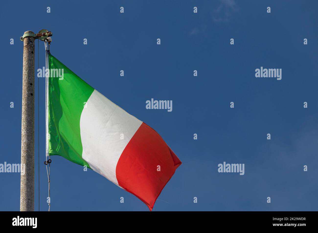 Italian flag blowing in the wind in the blue sky Stock Photo - Alamy