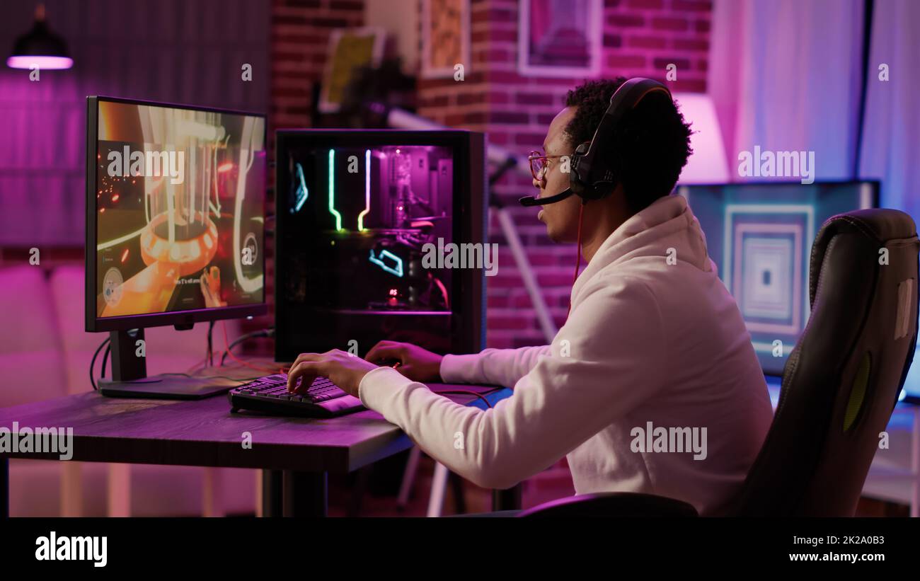 African american gamer relaxing playing online action game using pc ...