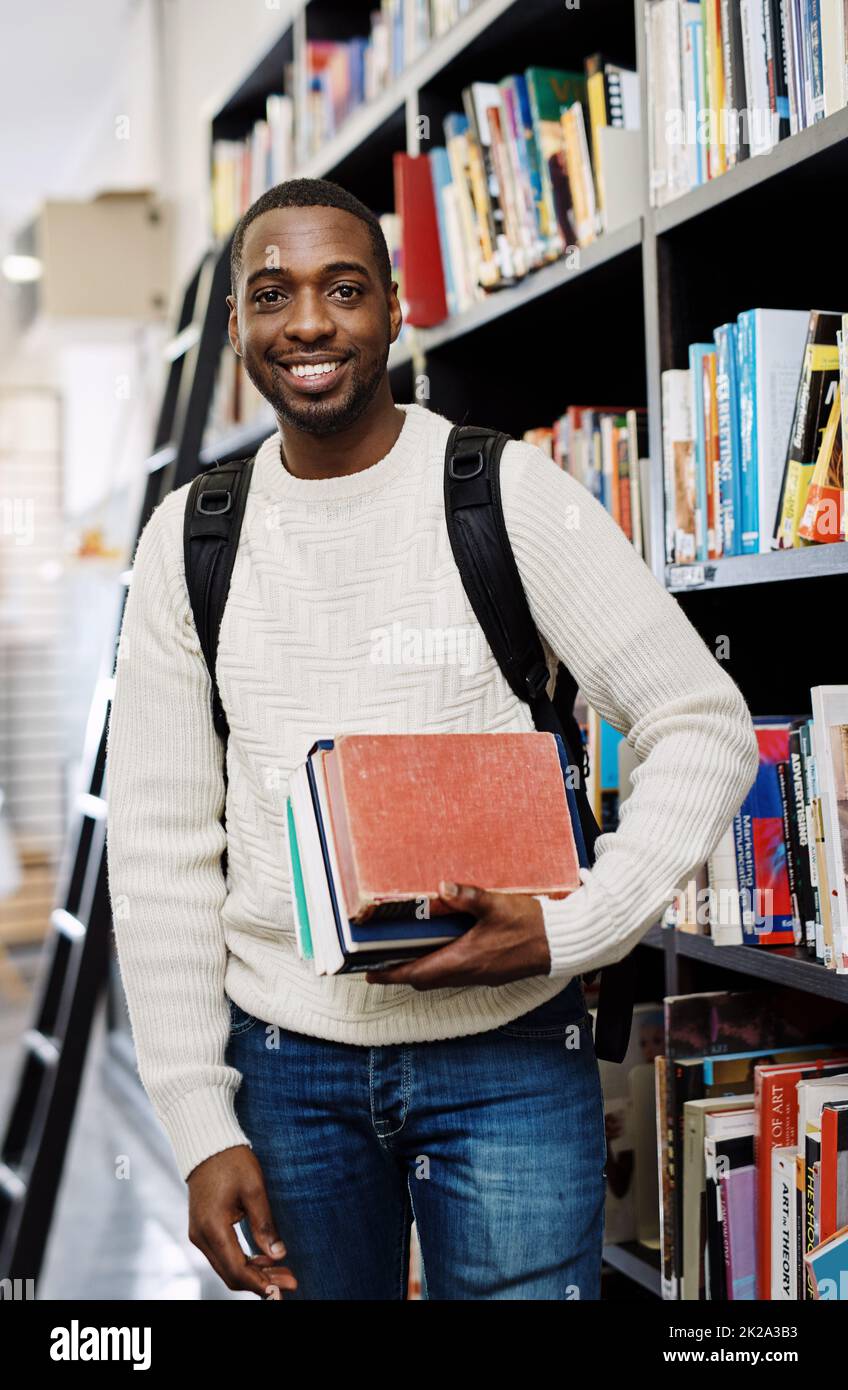 Student man holding book library smiling happy hi-res stock photography ...