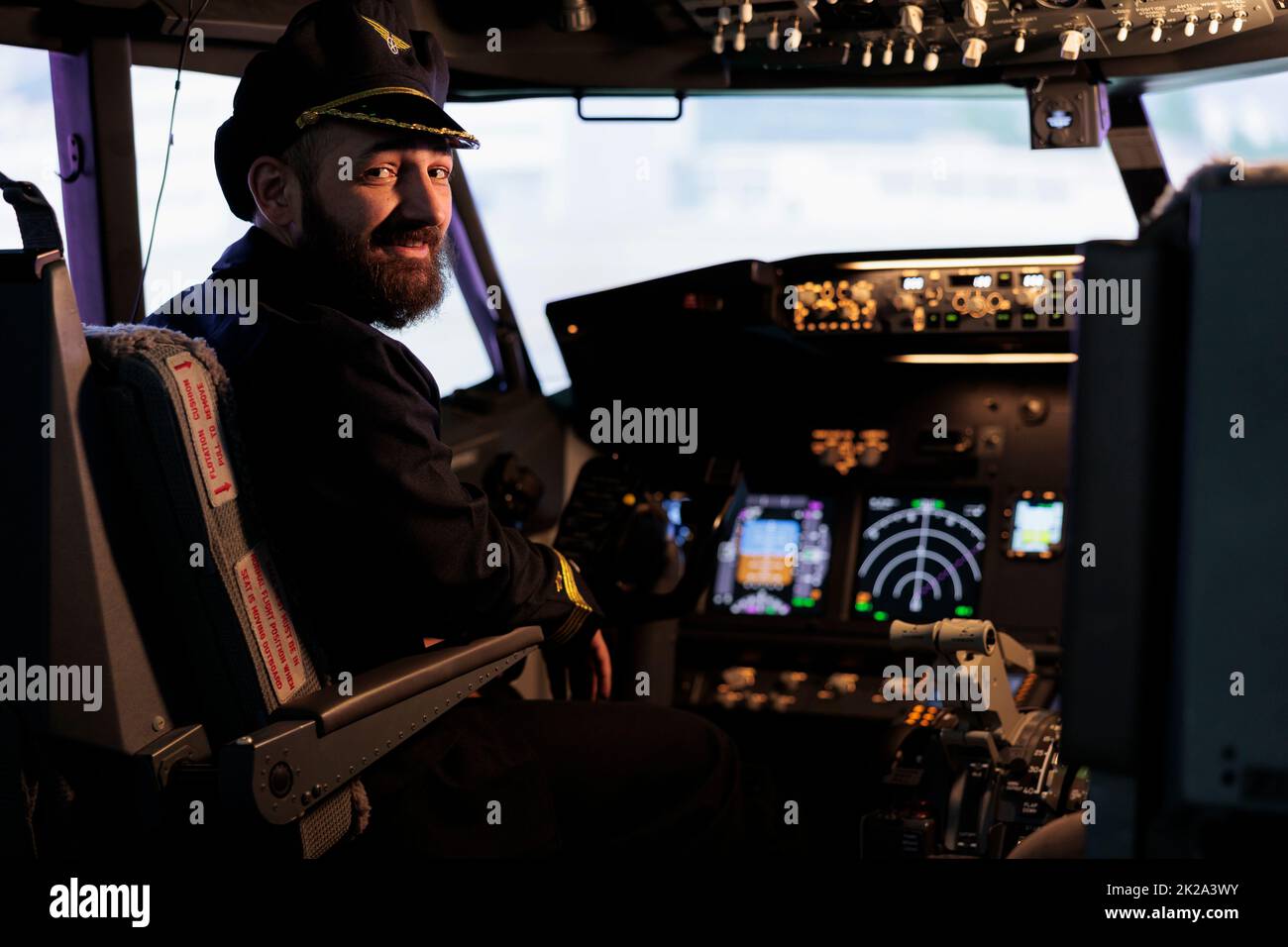 Portrait of male captain sitting in cabin ready to fly airplane with ...