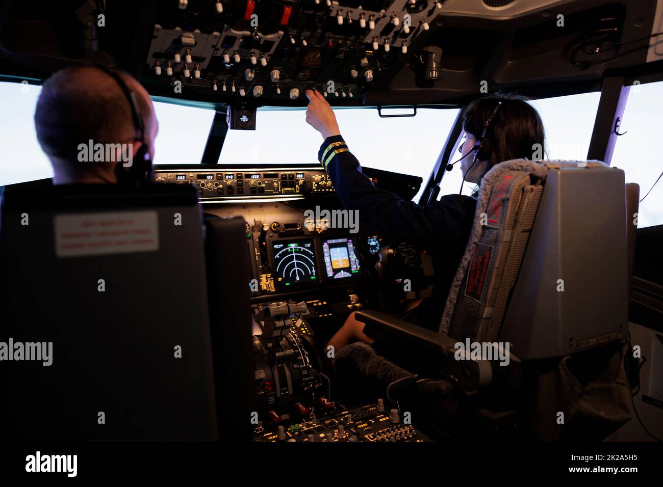 Female Pilot Assisting Captain To Takeoff And Fly Airplane Using Buttons On Dashboard Command