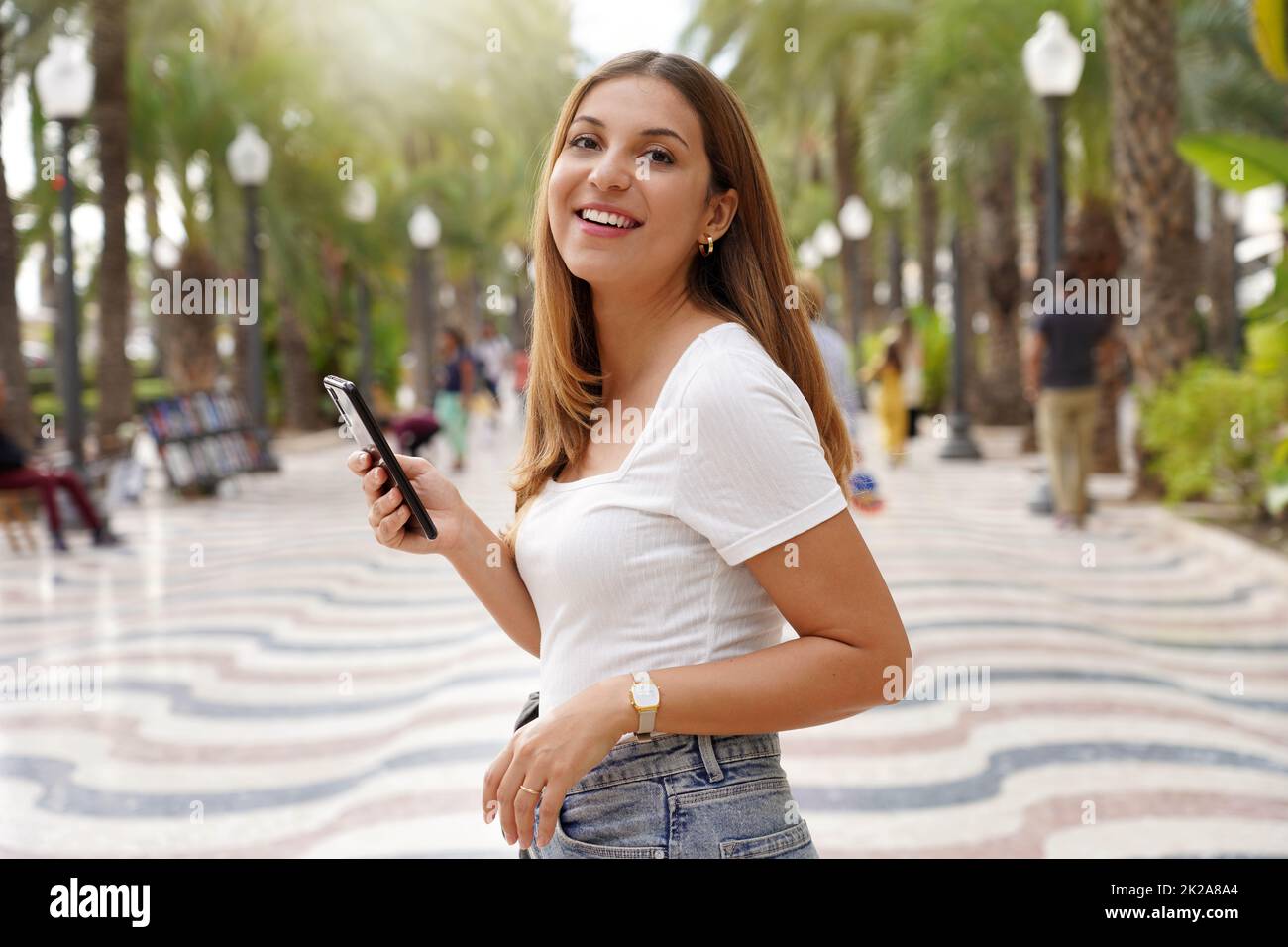 Fresh millennial girl using mobile phone turn around and looking at ...