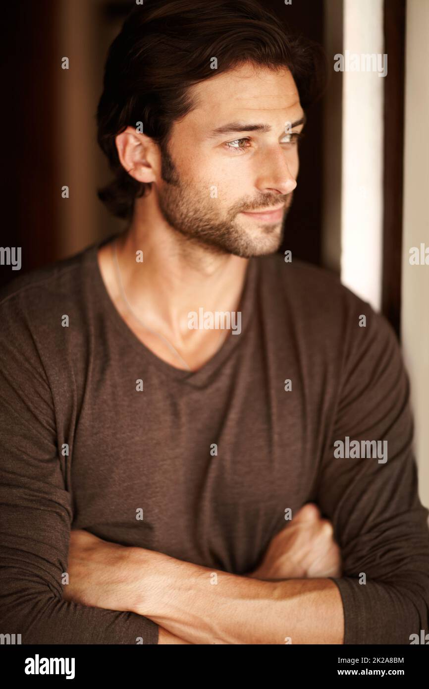 Content with his lot in life. A handsome young man gazing out of a ...