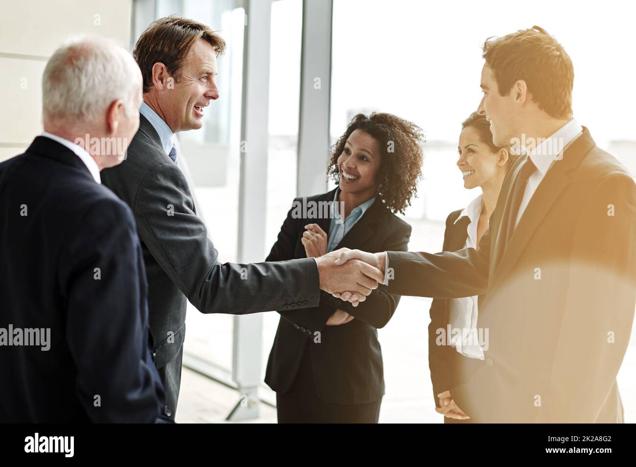 Teaming up. Cropped shot of two businesspeople shaking hands while ...