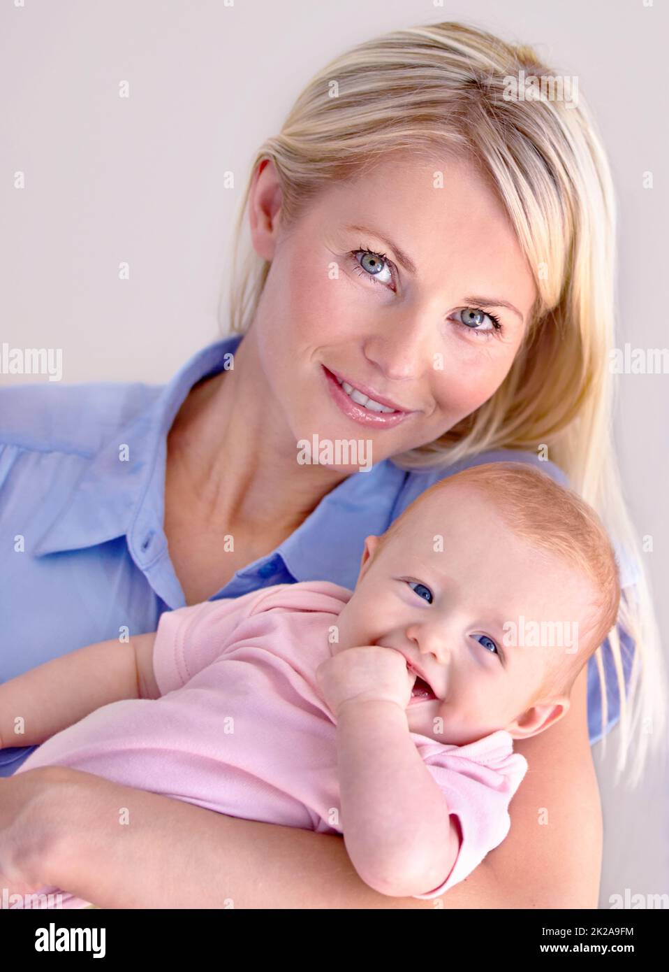 Perfect portrait. Young mother holding her cute baby while smiling at the camera Stock Photo - Alamy