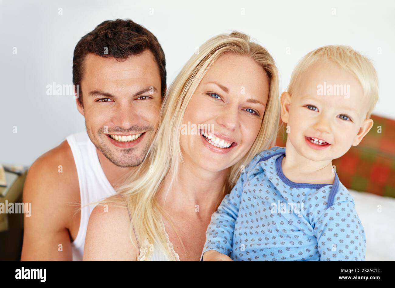 Perfect family portrait. Two parents smiiling at the camera with their ...