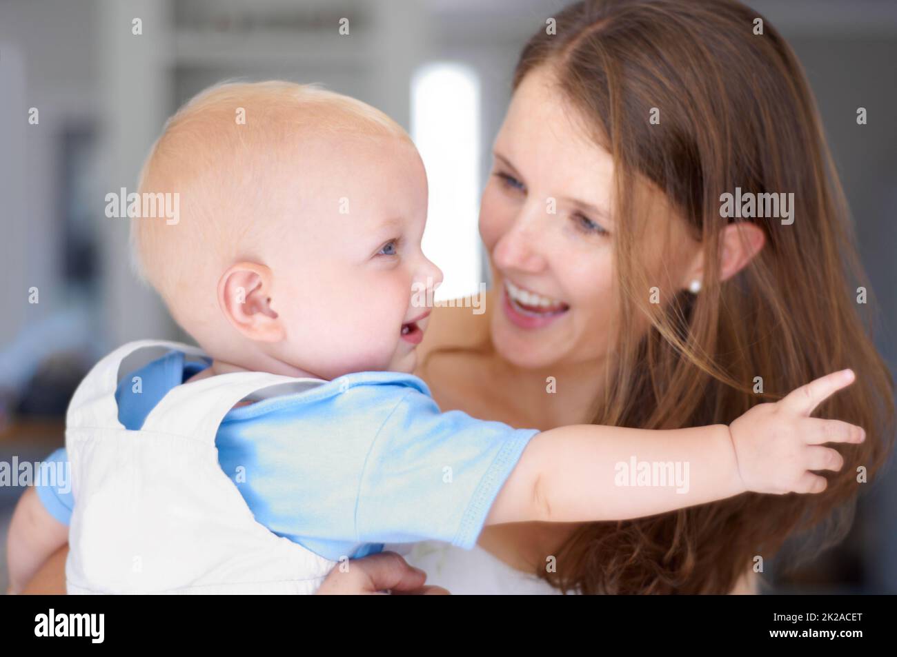 Whats that. Young beautiful mother holding her cute baby Stock Photo ... Whats that. Young beautiful mother holding her cute baby Stock Photo ...