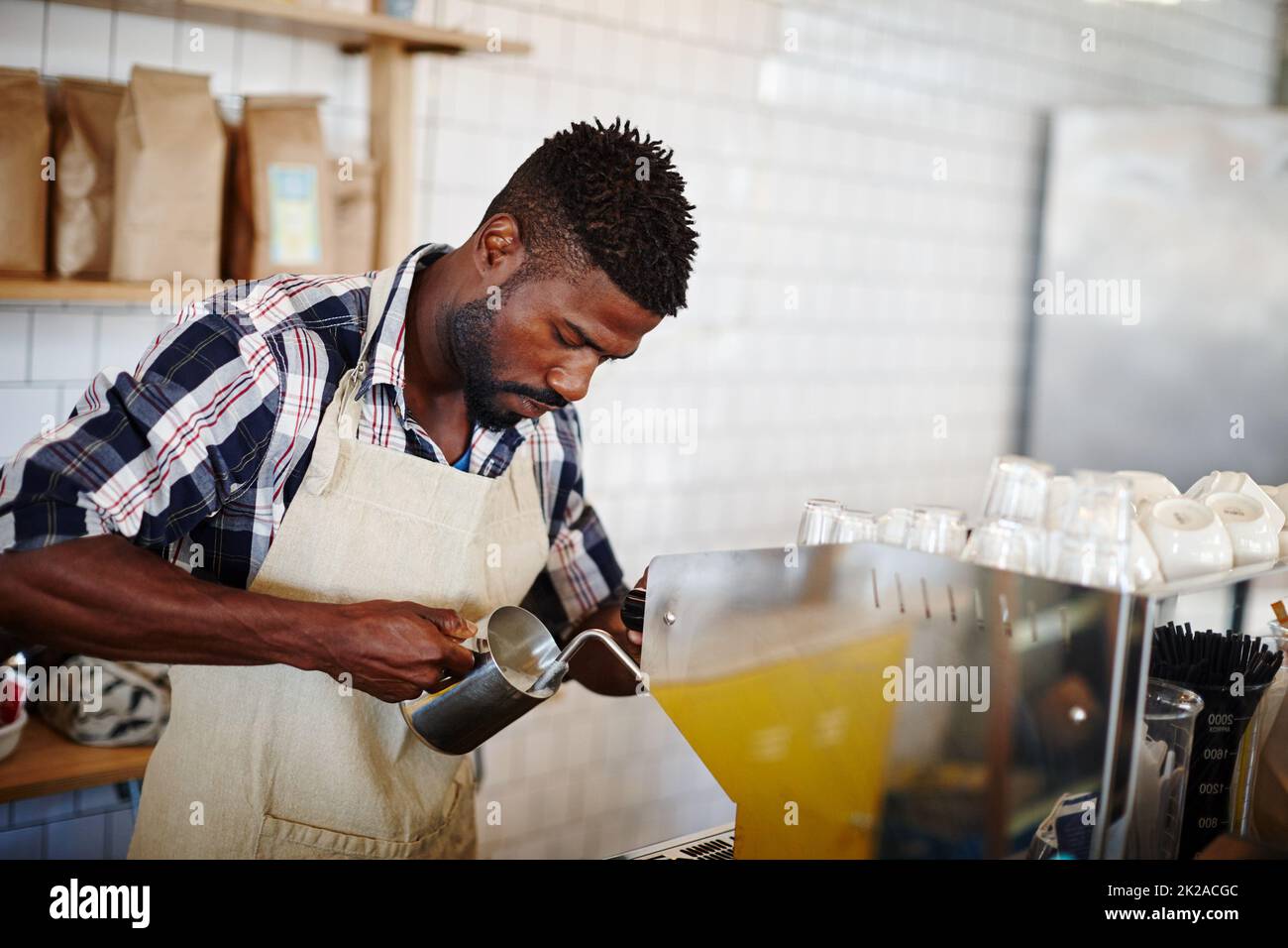 Coffee express. Cropped shot of a handsome male barista using an ...