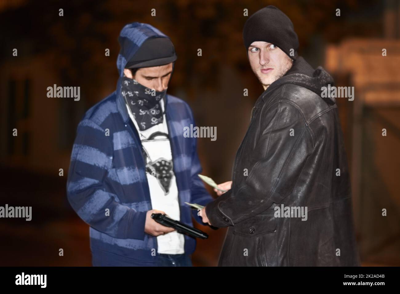 Underworld dealings. Two criminal doing a shady deal while wielding a ...