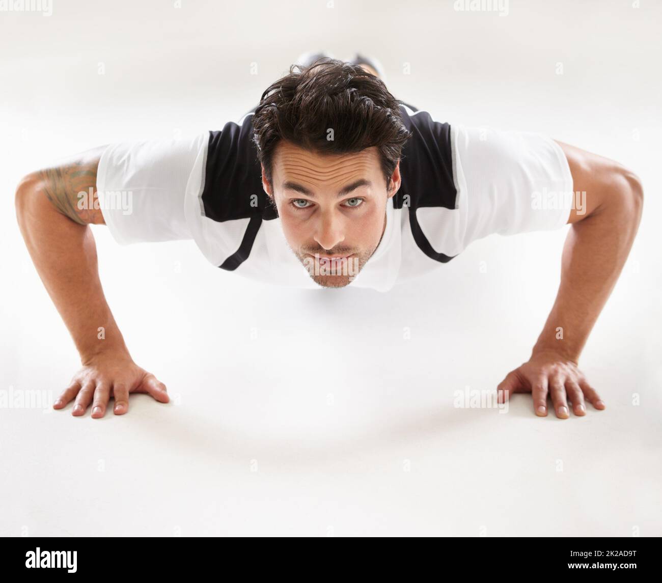 Getting his body in shape. Portrait of a young man doing push-ups Stock ...
