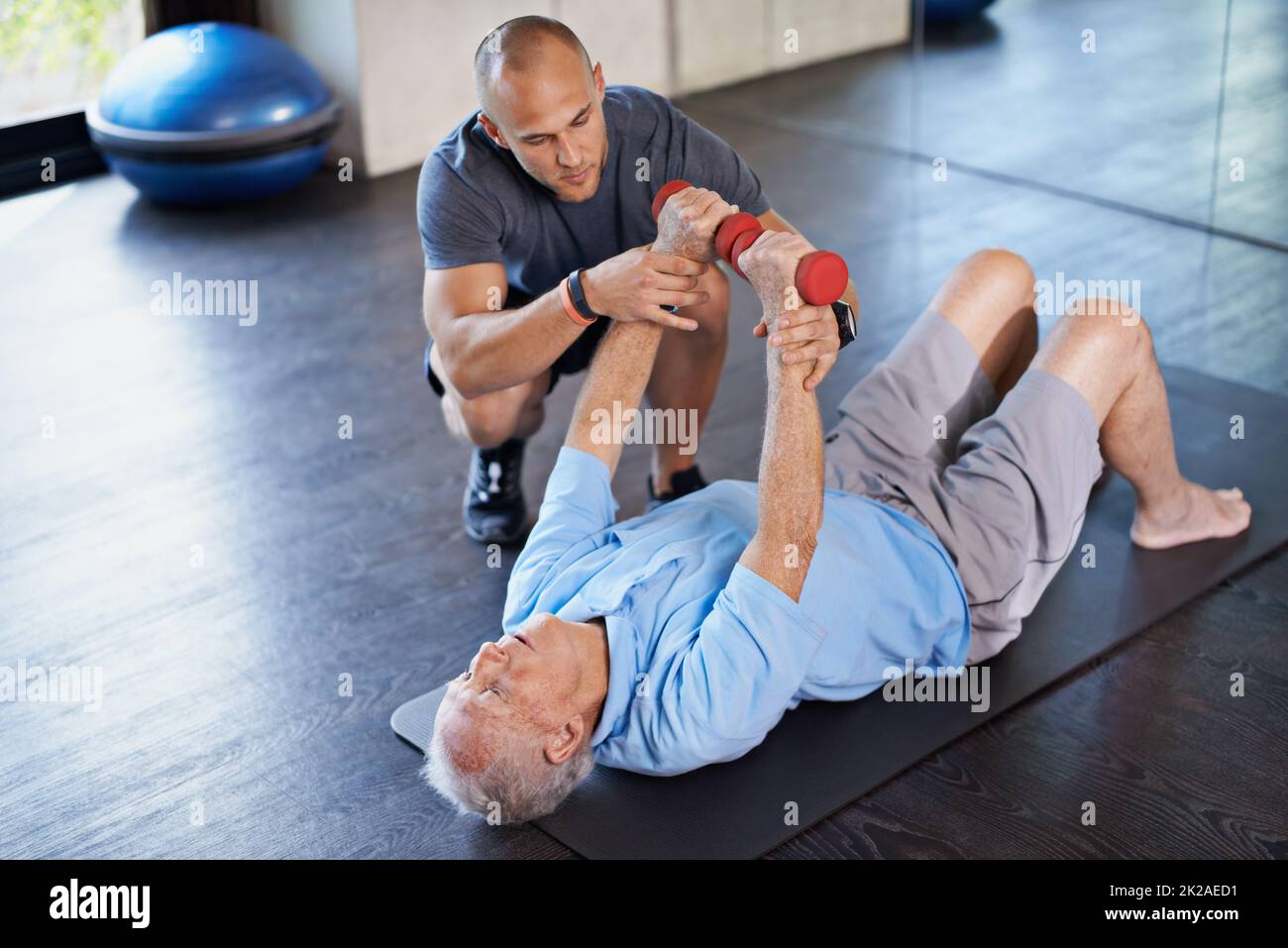 Guiding him back to wellness. a physiotherapist helping a senior man ...