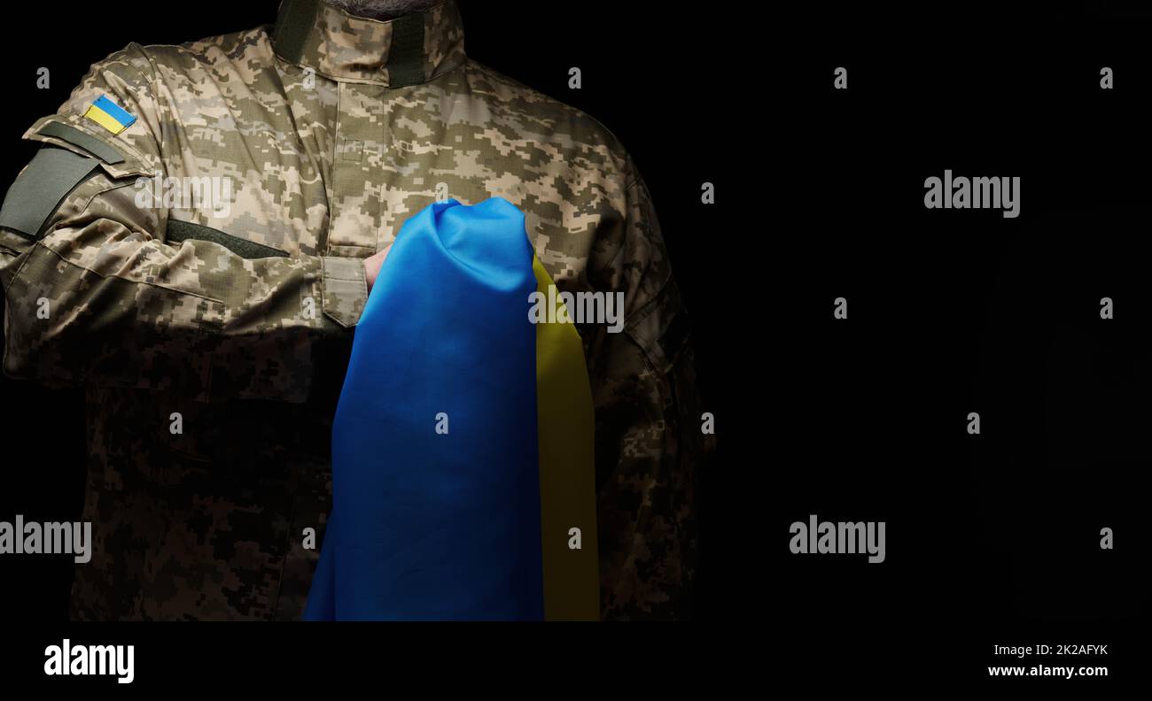 Ukrainian soldier holds a flag of the independent state of Ukraine ...