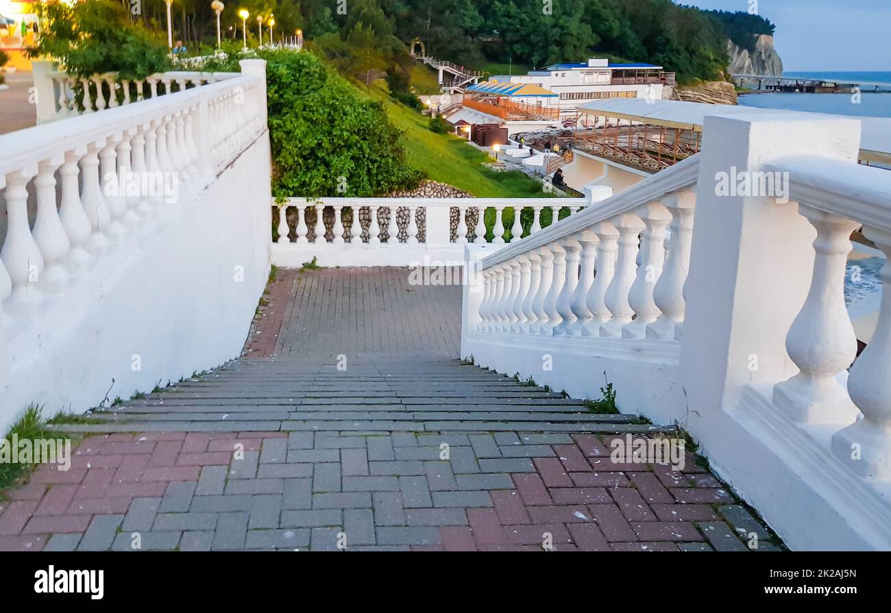 Classic white balustrade along the steps leading to the seashore, a ...