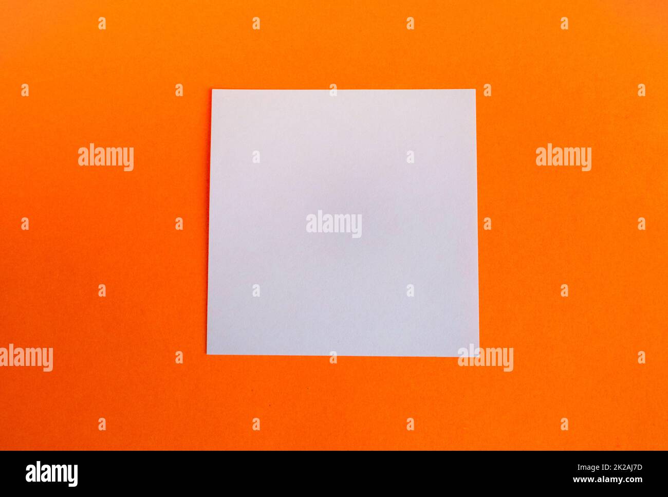 An empty square white composition on a bright orange background ...
