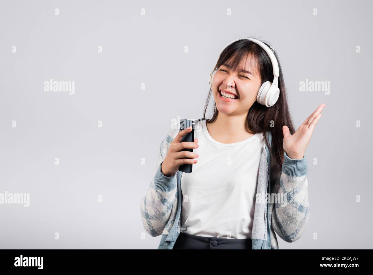 Woman excited smiling listening to music radio in bluetooth headphones ...