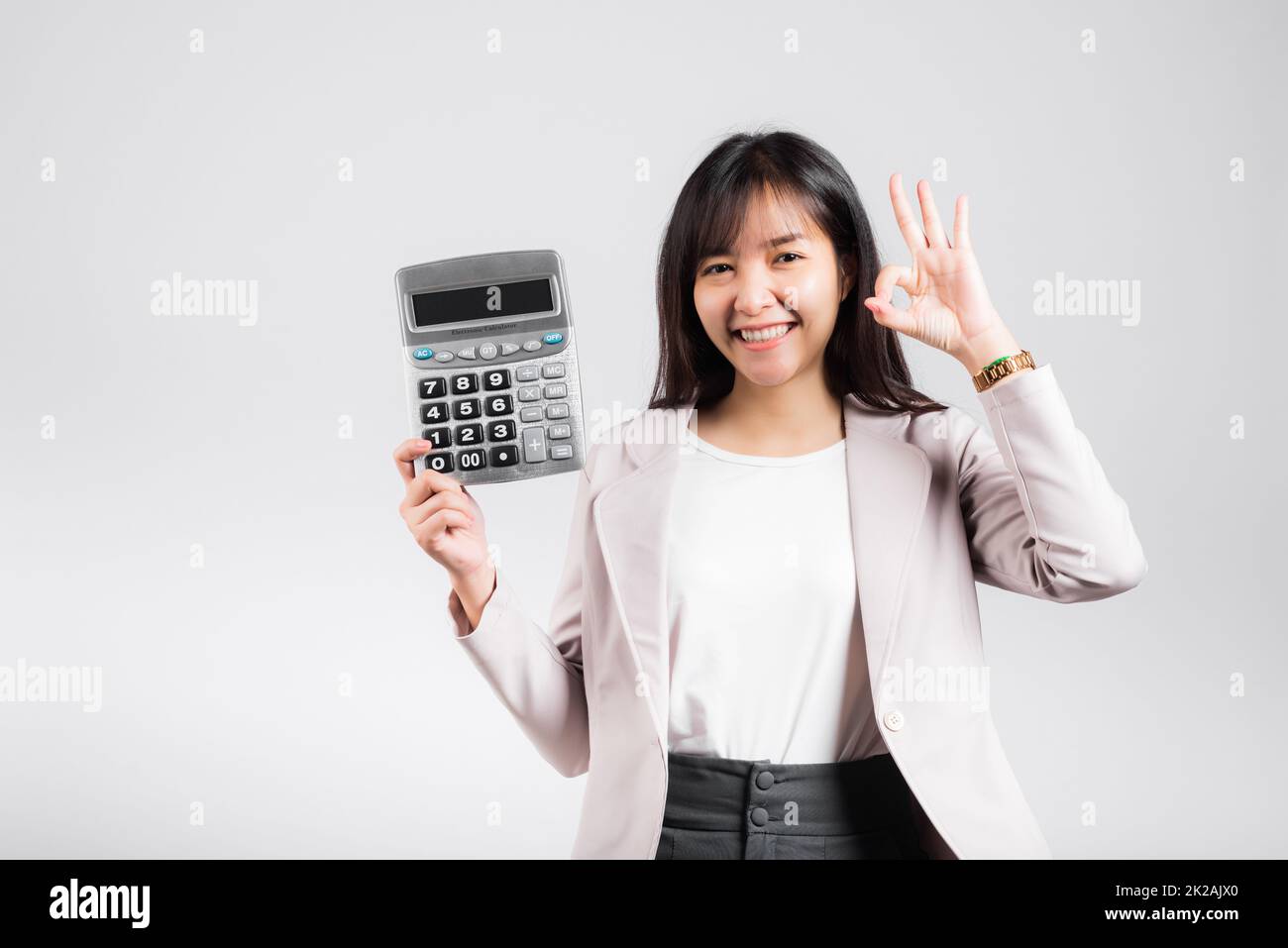 Woman confident smiling holding electronic calculator and show OK ...