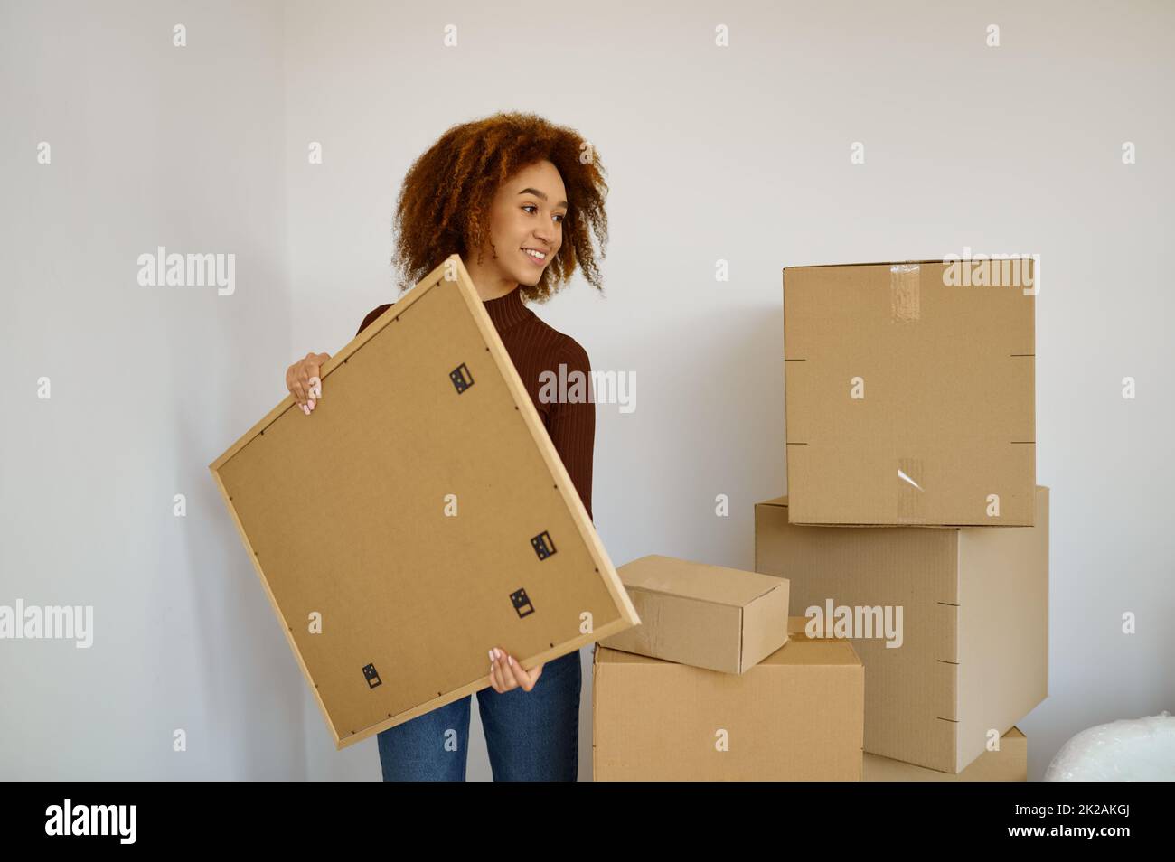 Woman taking off picture surrounded cardboard boxes Stock Photo - Alamy
