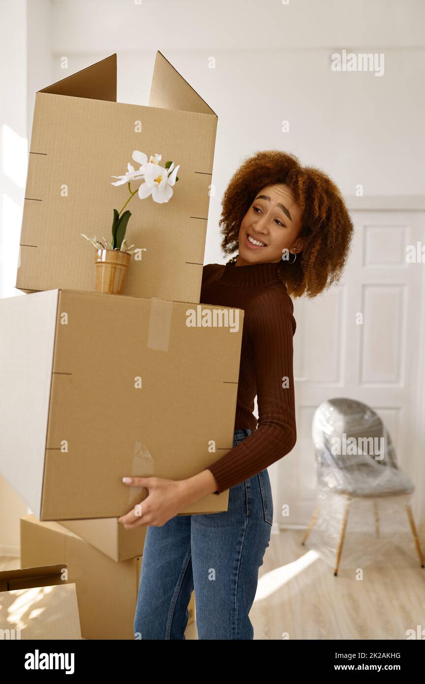 Portrait of woman holding heavy cardboard box Stock Photo - Alamy