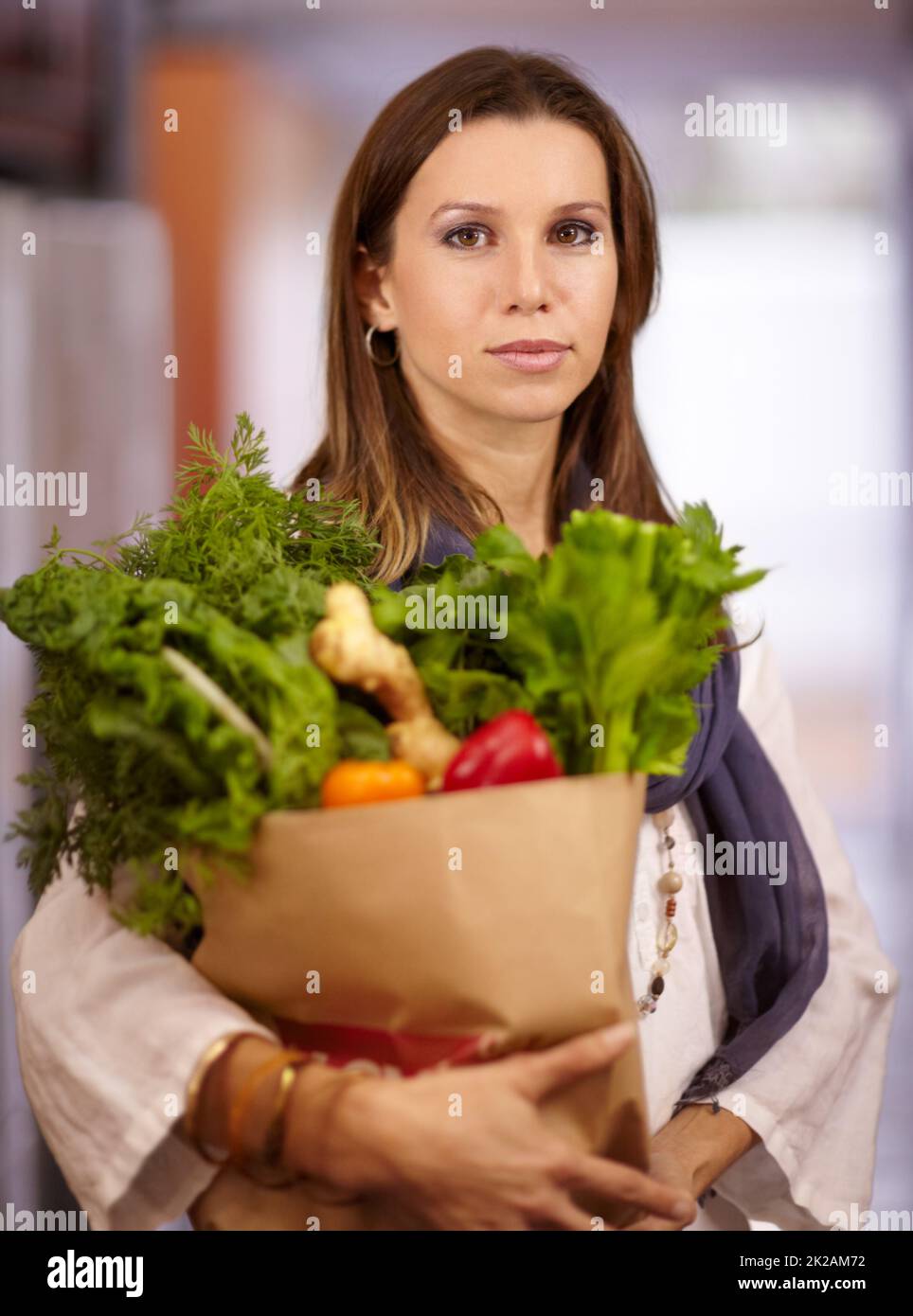 She knows the value of healthy food choices. Attractive woman holding a ...