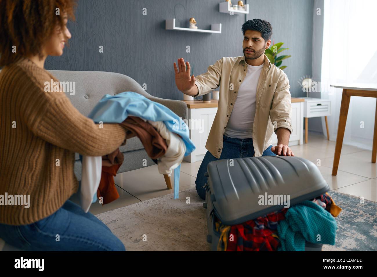 Multiracial couple packing clothes into travel suitcase Stock Photo - Alamy