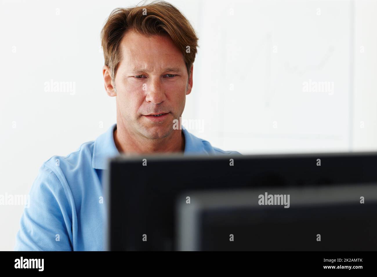 One screen holds all his attention. Shot of a mature man concentrating ...