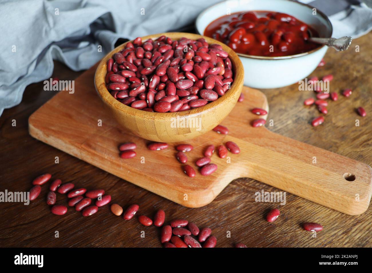 Raw and canned red kidney chilli beans in bowl on a rustic wooden table ...