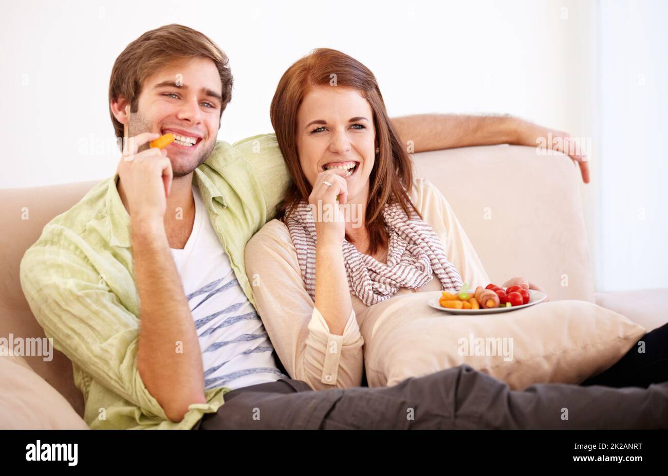 Relaxing with good food and better company. A young couple relaxing on ...